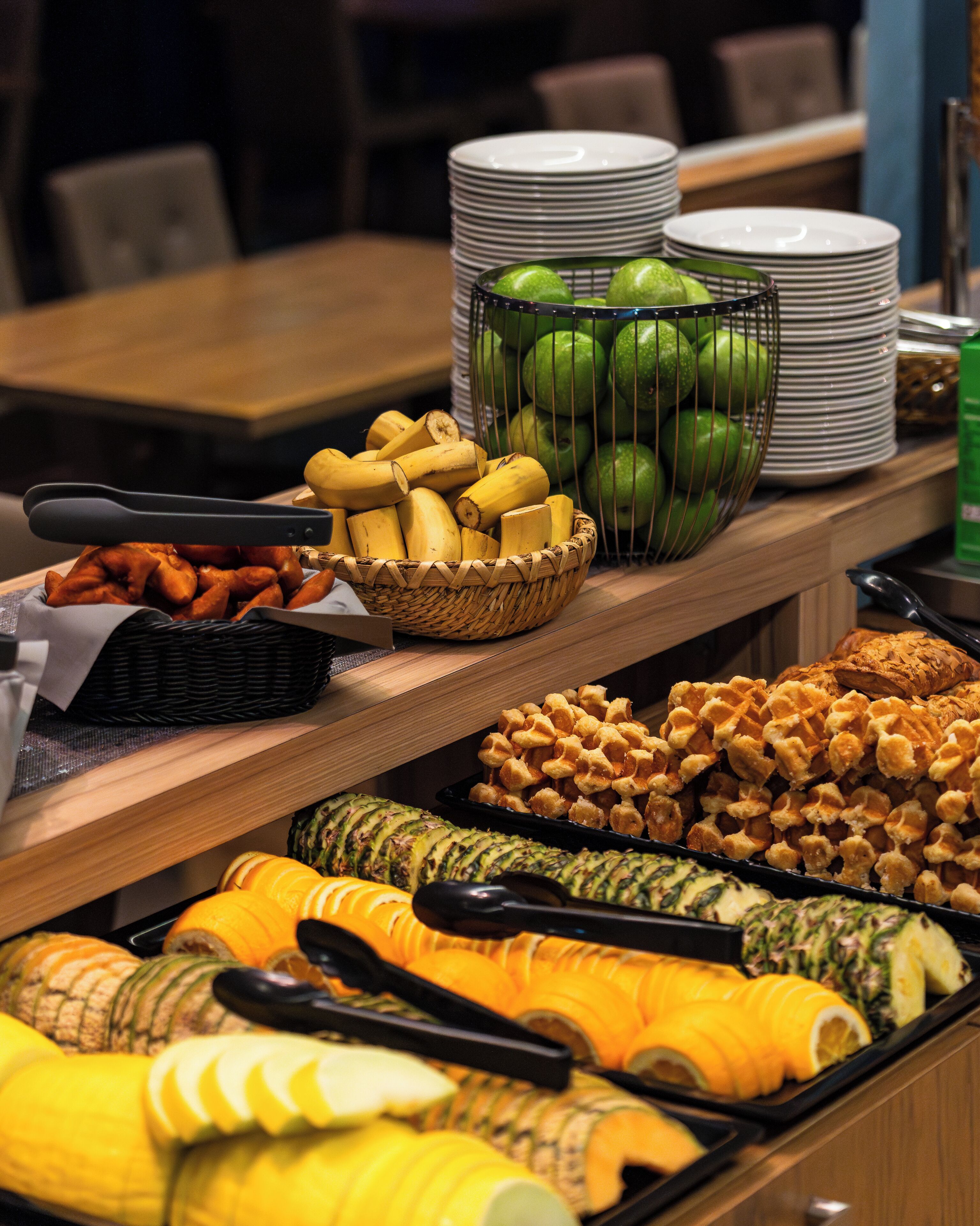 Buffet com diversos alimentos, incluindo frutas, legumes e doces.