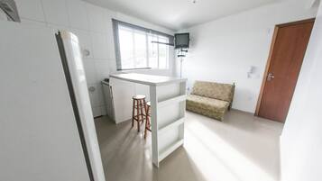 Um frigorífico, um forno, uma placa de cozinha, utensílios de cozinha