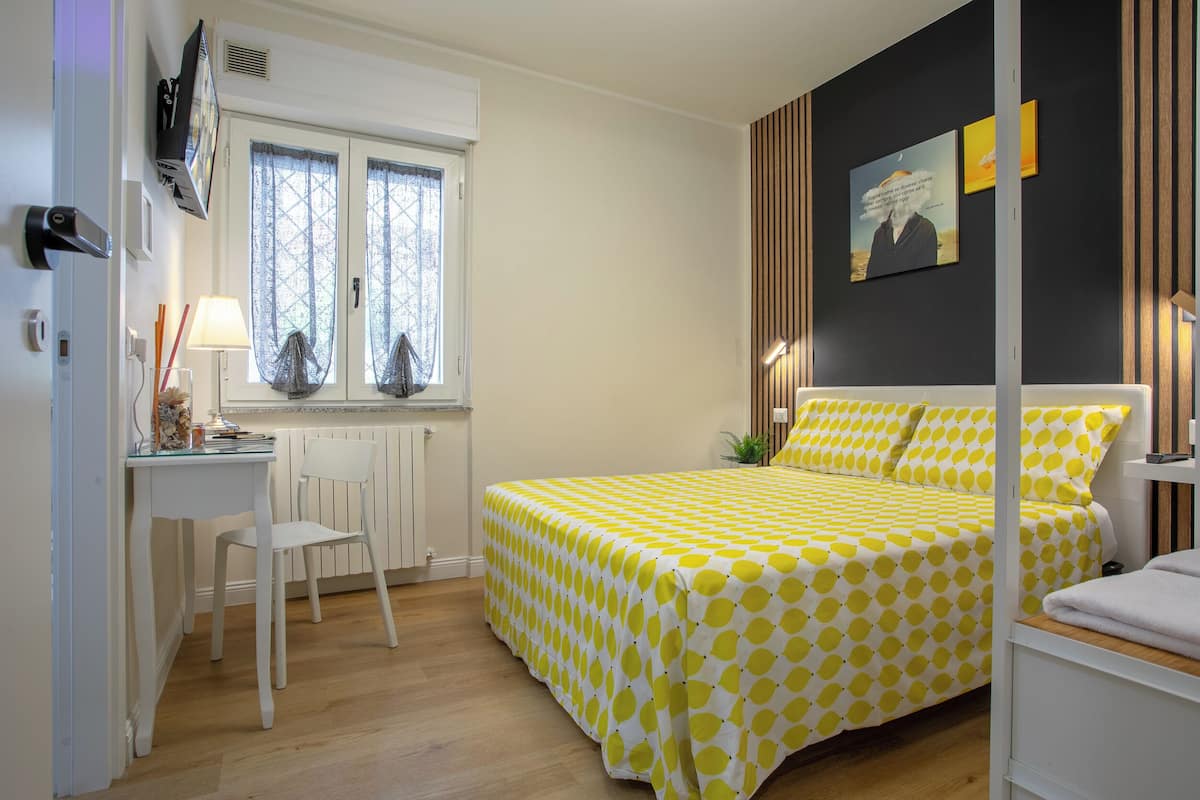 Quarto com cama, escrivaninha e cadeira.