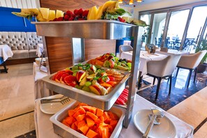 Um buffet com diversas frutas e legumes.