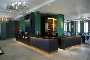 Uma área de bar com balcão, banquetas e uma seleção de garrafas.