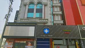 Um edifício com a placa 'Diamond Motel' e um logotipo de estrela azul.