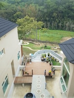 Edifício residencial com terraço no telhado, escadaria e vista para uma área arborizada.