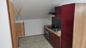 Uma cozinha compacta com fogão, pia e armários.