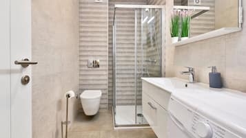 Apartamento Deluxe, 1 quarto, pátio, vista para o jardim | Casa de banho | Um polibã, um secador de cabelo, toalhas fornecidas, papel higiénico