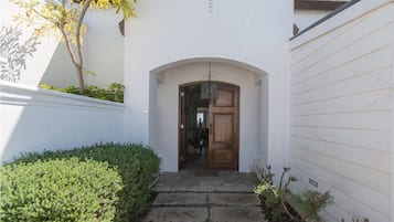 Uma casa branca com um caminho de pedra que leva a uma porta de madeira.