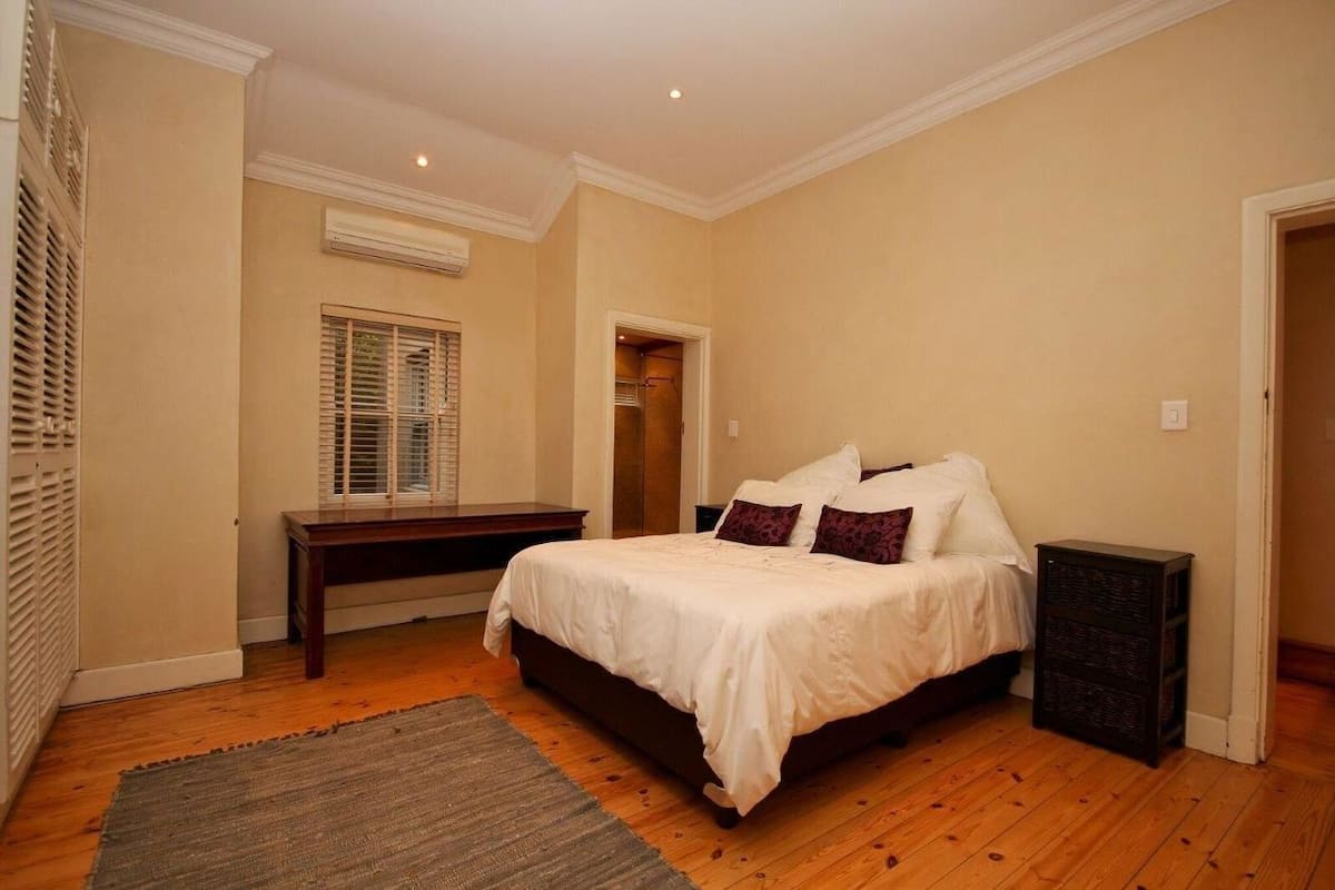 Um quarto com uma cama, uma escrivaninha e um guarda-roupa.