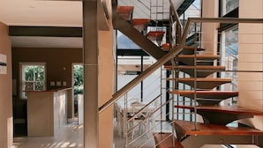 Um interior moderno com escada, área de cozinha e espaço para refeições.