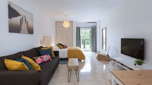 Uma sala de estar moderna com sofá, mesa de centro, TV e varanda com vista.
