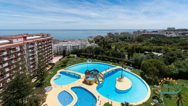 Um resort com várias piscinas, incluindo uma grande piscina central, e vista para o mar.