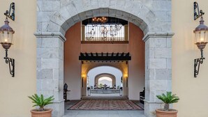 Uma entrada em arco com vista para uma piscina e um terraço.