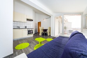 Apartamento Familiar, várias camas, Vista para a cidade | Kitchenette privada | Um frigorífico/congelador grande, uma placa de cozinha 