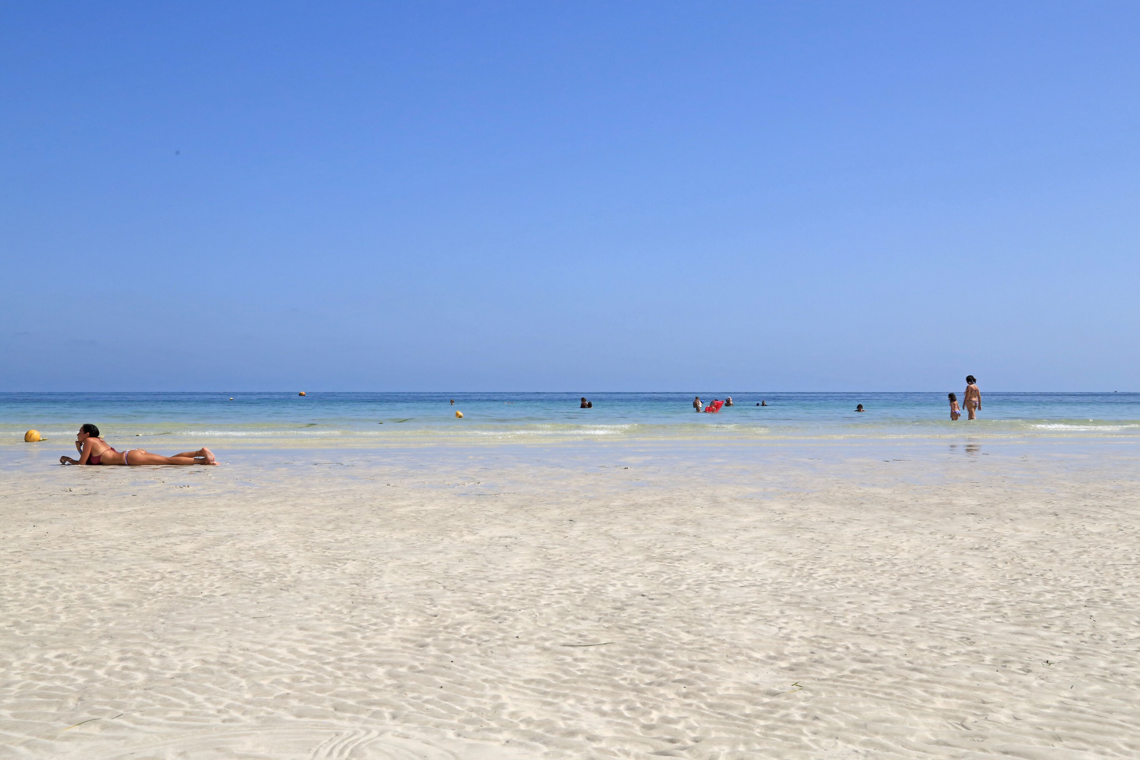 Uma praia com pessoas se banhando e nadando.