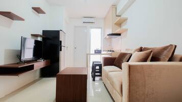 Uma sala de estar moderna com televisão de tela plana, sofá, mesa de centro e estantes embutidas.