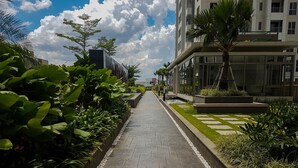 Um caminho ladeado por vegetação exuberante e edifícios modernos.