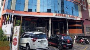 Um edifício com vários andares e fachada de vidro, com uma placa que diz "Apple & Pear".