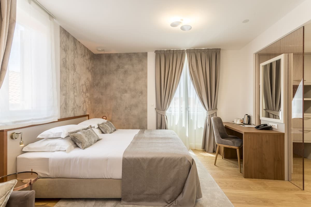 Quarto moderno com cama grande, escrivaninha e guarda-roupa.