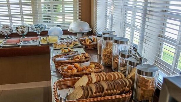 Um buffet com diversos tipos de comida e pão.