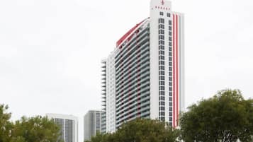 Um hotel alto com um padrão distinto de listras vermelhas e brancas na fachada.