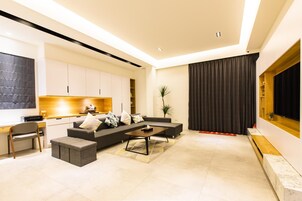 Uma sala de estar moderna com sofá, mesa de centro e televisão.
