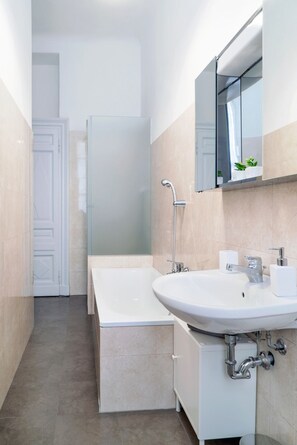 Apartamento, 3 quartos | Casa de banho | Um polibã e uma banheira separados, uma banheira de imersão total 