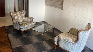 Uma sala de estar moderna com dois poltronas e uma mesa de centro de vidro.