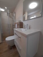 Apartamento Cidade, vista para o pátio | Casa de banho | Um polibã, artigos de higiene pessoal grátis, um secador de cabelo 