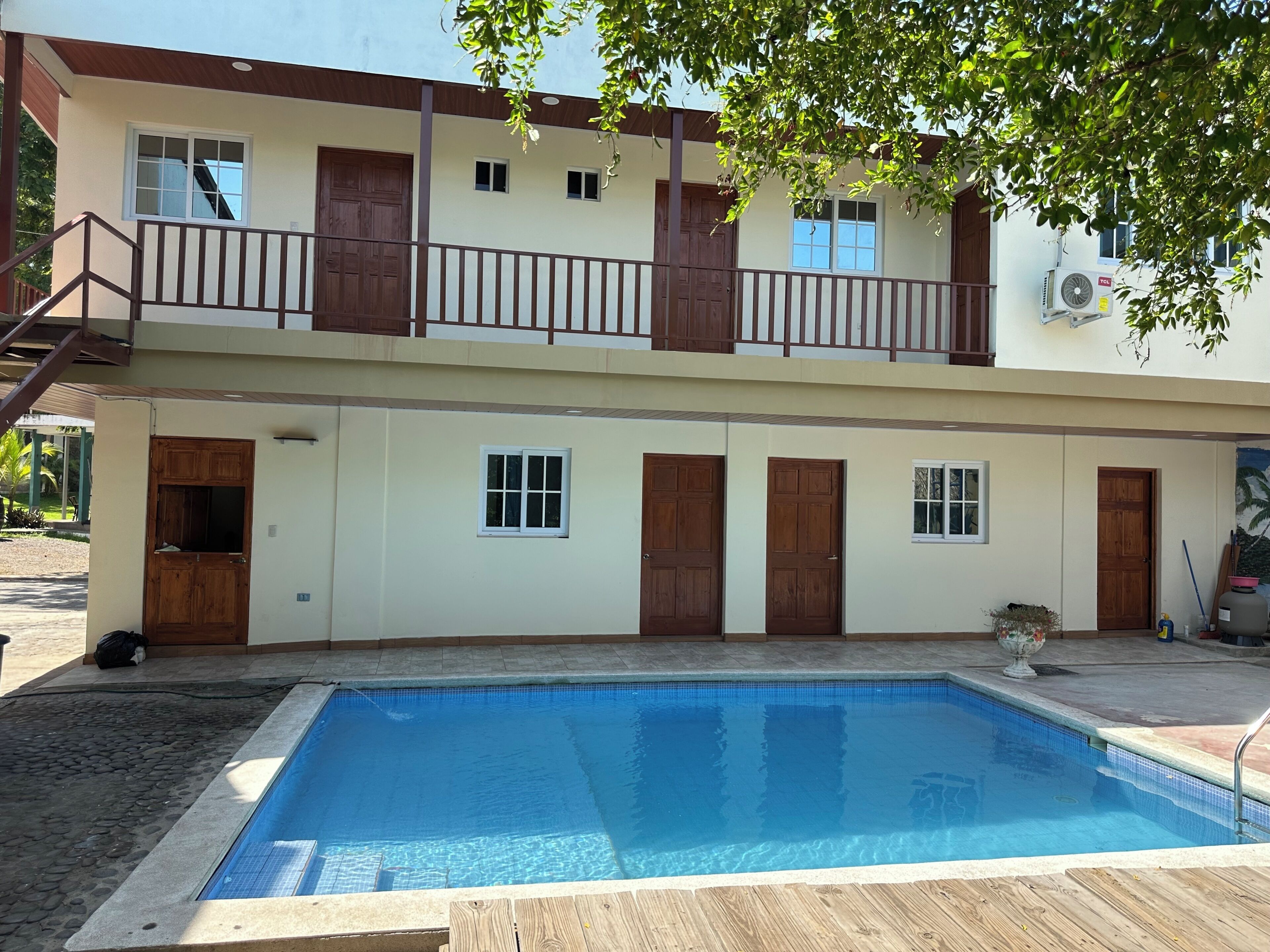 Um edifício de dois andares com uma piscina em primeiro plano.