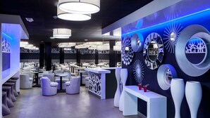 Uma área de estar moderna e bem iluminada, com móveis brancos e obras de arte decorativas nas paredes.