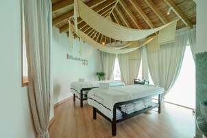 Quarto com duas camas, teto de madeira e um letreiro com a inscrição 'Elizabeth Arden PRO'.