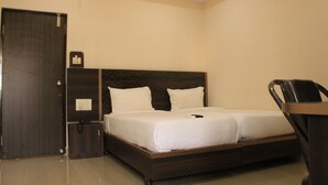 Uma cama de casal com cabeceira de madeira, mesa de cabeceira e uma cadeira.