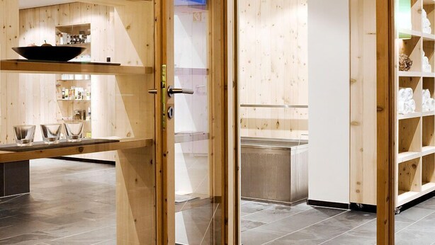 Interior de madeira com uma porta deslizante que dá para uma cozinha.