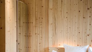 Um quarto com painéis de madeira, uma cama e um espelho.