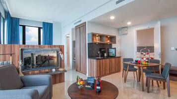 Quarto de hotel moderno com área de estar, cozinha e espaço para refeições.
