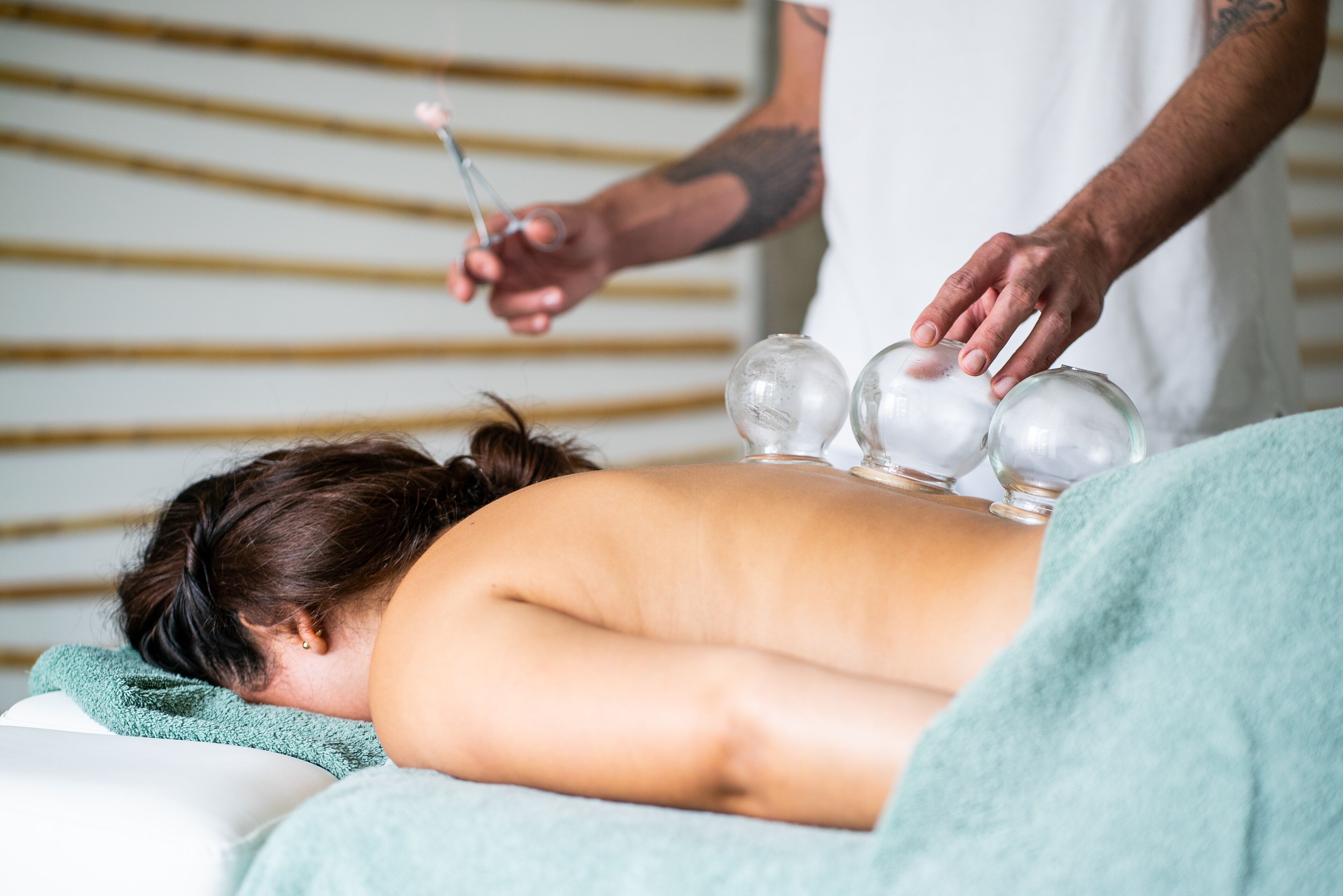 Uma pessoa recebendo tratamento facial, com um terapeuta aplicando máscara no rosto.