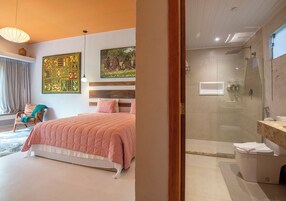 Quarto moderno com cama grande, área de chuveiro e banheiro com banheira.