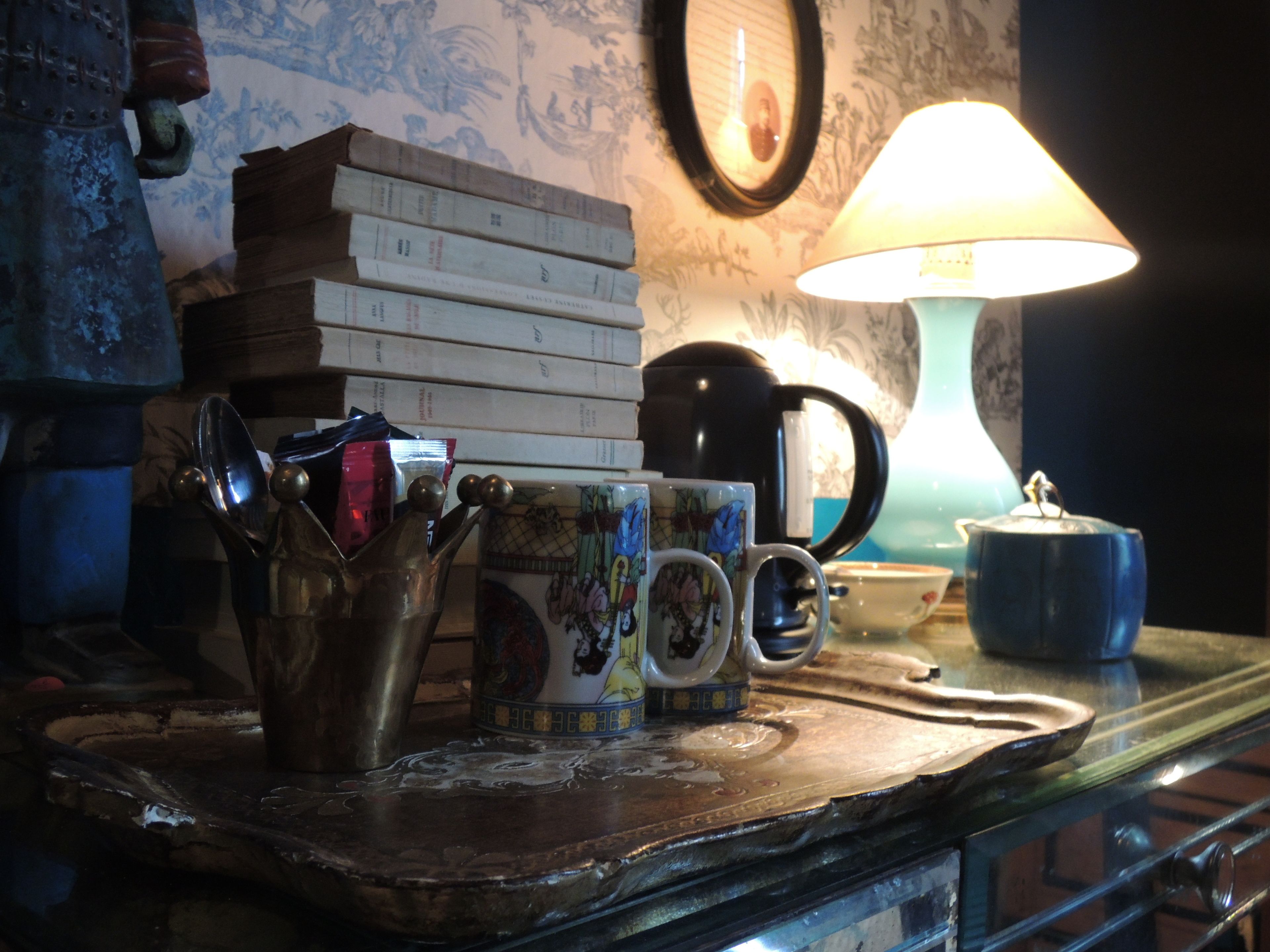 Uma mesa com livros, canecas e uma chaleira.