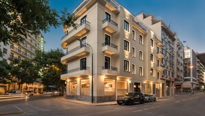 Um hotel de vários andares com varandas, janelas amplas e fachada bem iluminada.