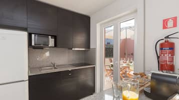 Apartamento, 1 quarto, terraço | Cozinha privada | Geladeira grande, micro-ondas, cooktop, cafeteira/chaleira