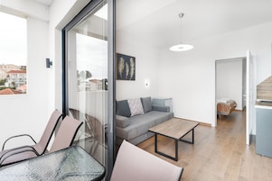 Apartamento Panorâmico, 1 cama queen-size e sofá-cama, vista para o mar | Sala de estar | TV de ecrã plano