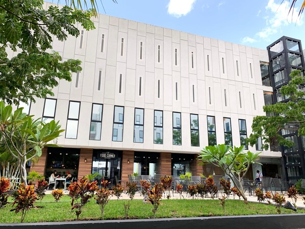Um edifício moderno com fachada plana, várias janelas e uma placa com a inscrição 