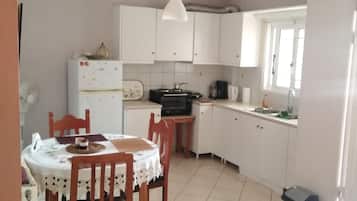 Um frigorífico, um forno, uma placa de cozinha, uma cafeteira/bule