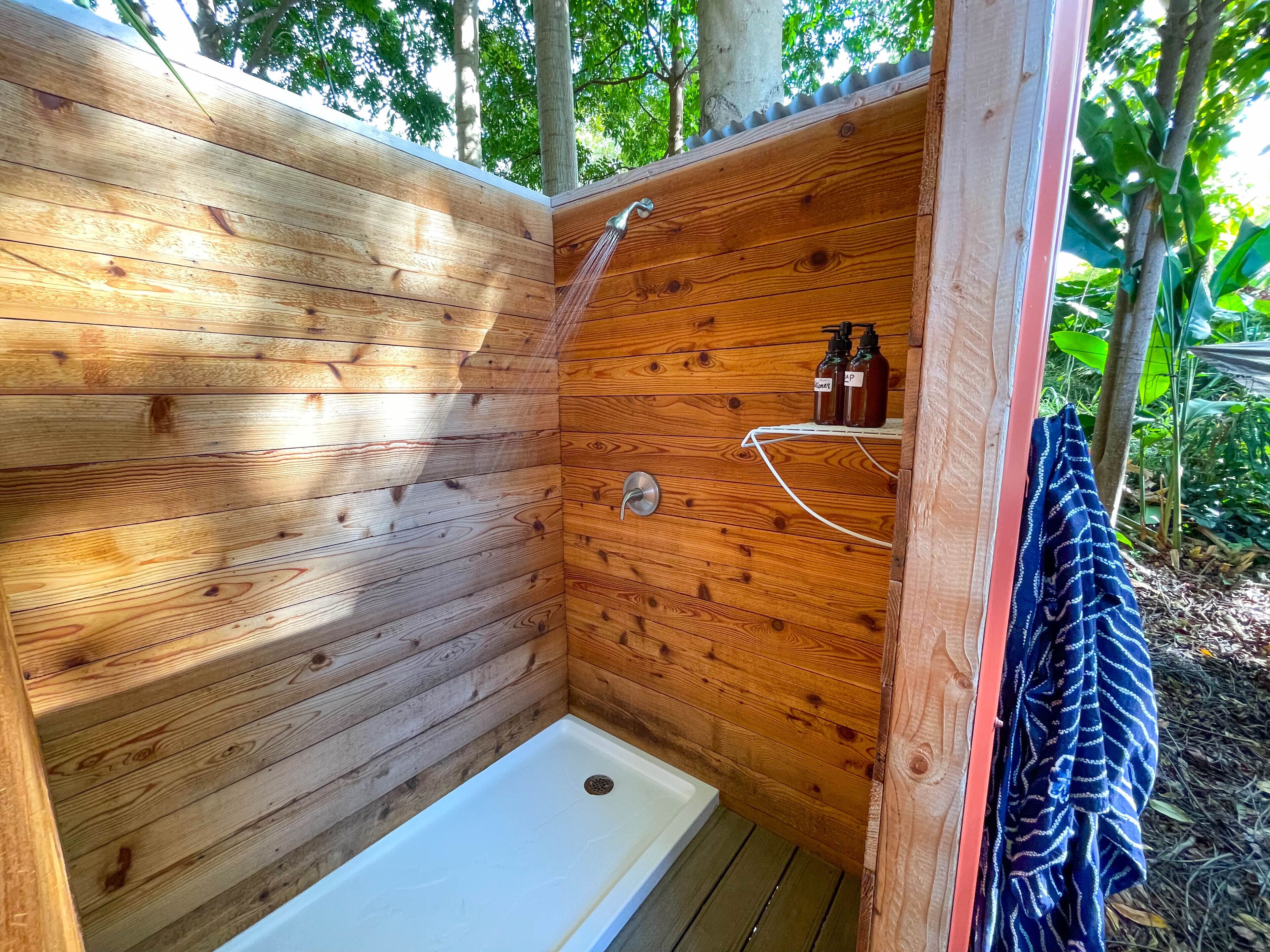 Uma cabana de madeira com banheira e chuveiro integrados.