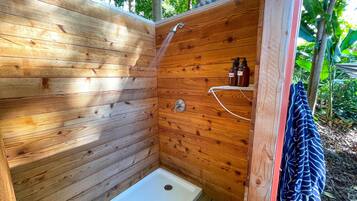 Uma cabana de madeira com banheira e chuveiro integrados.