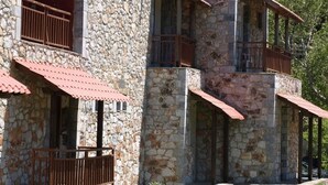 Um edifício de pedra com várias varandas e telhados em telhas vermelhas.
