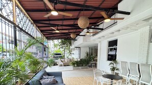 Uma área de estar moderna com um sofá, cadeiras brancas e uma mesa de jantar.