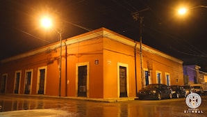 Um edifício de dois andares com várias janelas e uma placa indicando os números dos quartos.