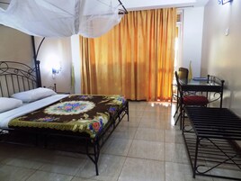 Um quarto com uma cama, uma escrivaninha e uma cadeira.