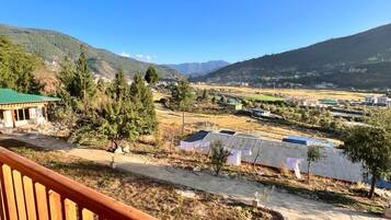 Varanda com vista para paisagem rural, incluindo campos e colinas ao longe.