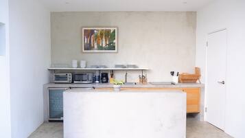 Um frigorífico/congelador grande, um micro-ondas, uma placa de cozinha